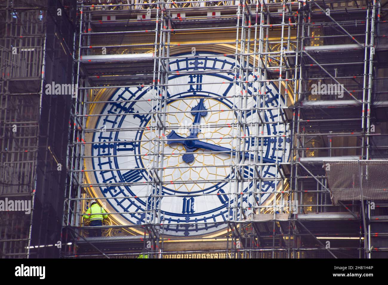 London, UK. 26th November 2021. Workers renovate the clock face as ...