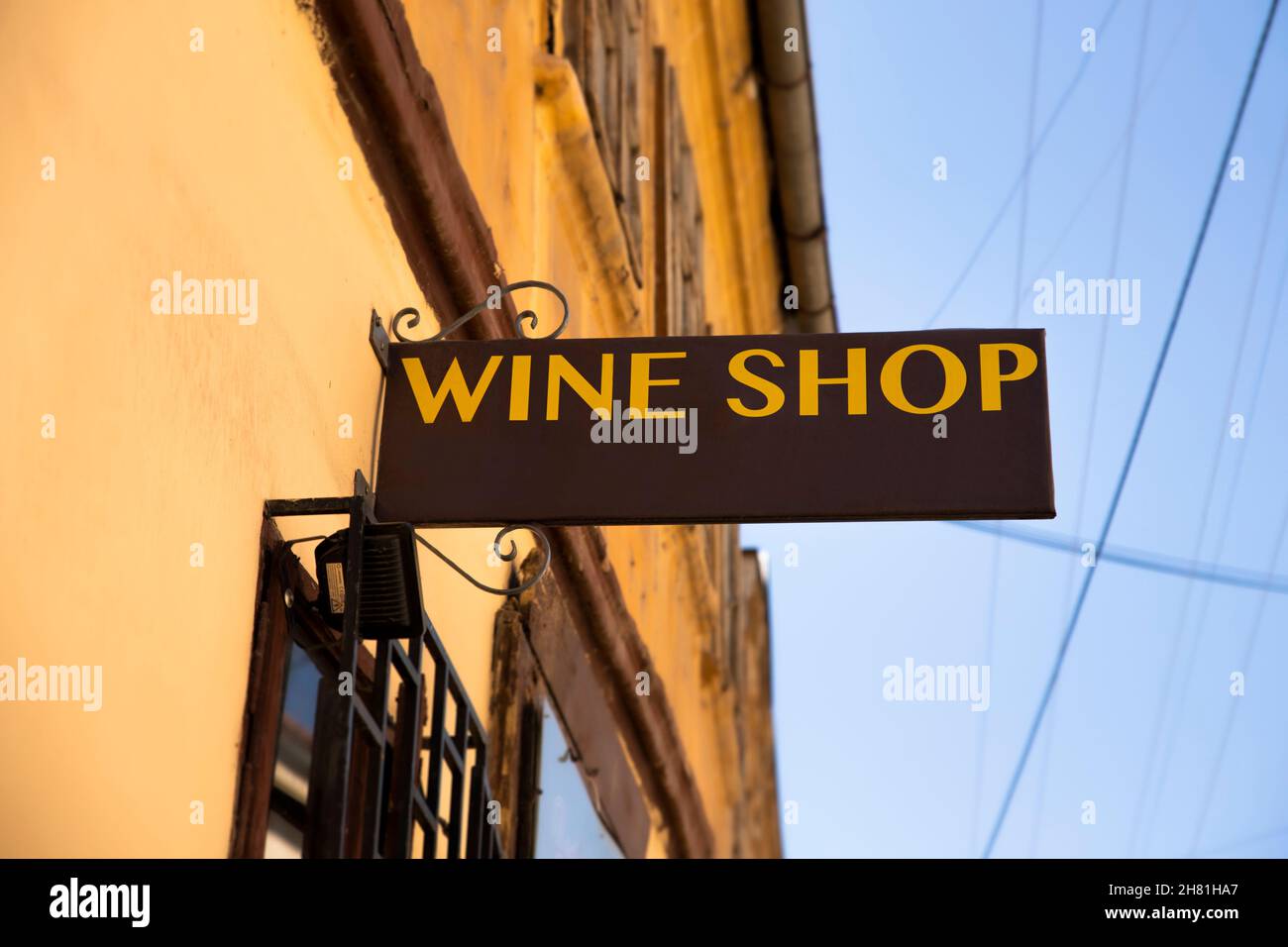 Wine shop sign hanging from old building Stock Photo - Alamy