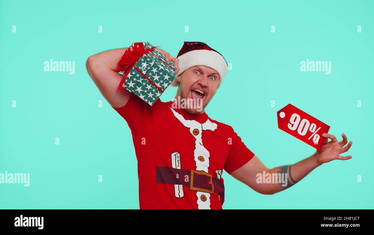 Man in red Christmas t-shirt showing gift box and 90 Percent discount ...