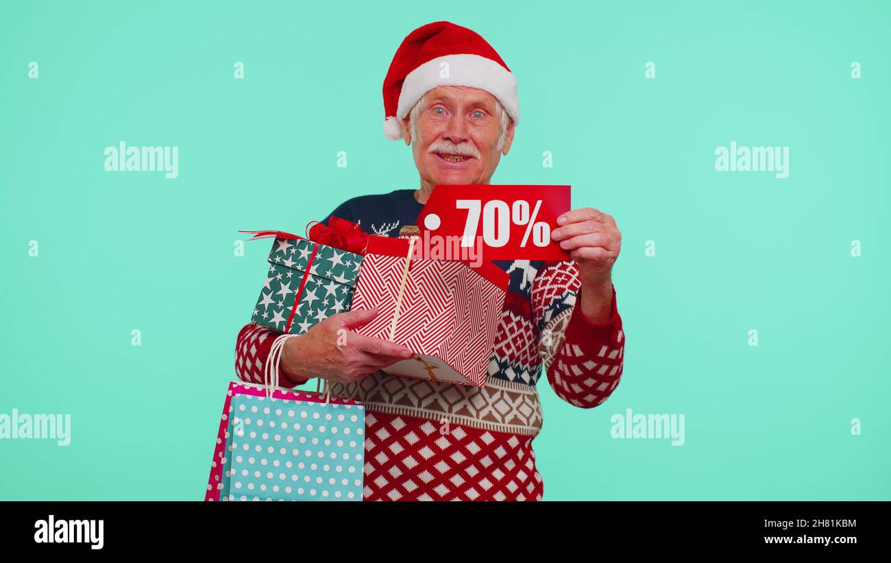 Mature man in Christmas sweater showing gift box and 70 Percent ...