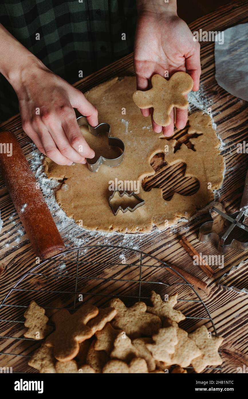 Top-view of a female baker's hands cutting ginger cookies for Christmas ...