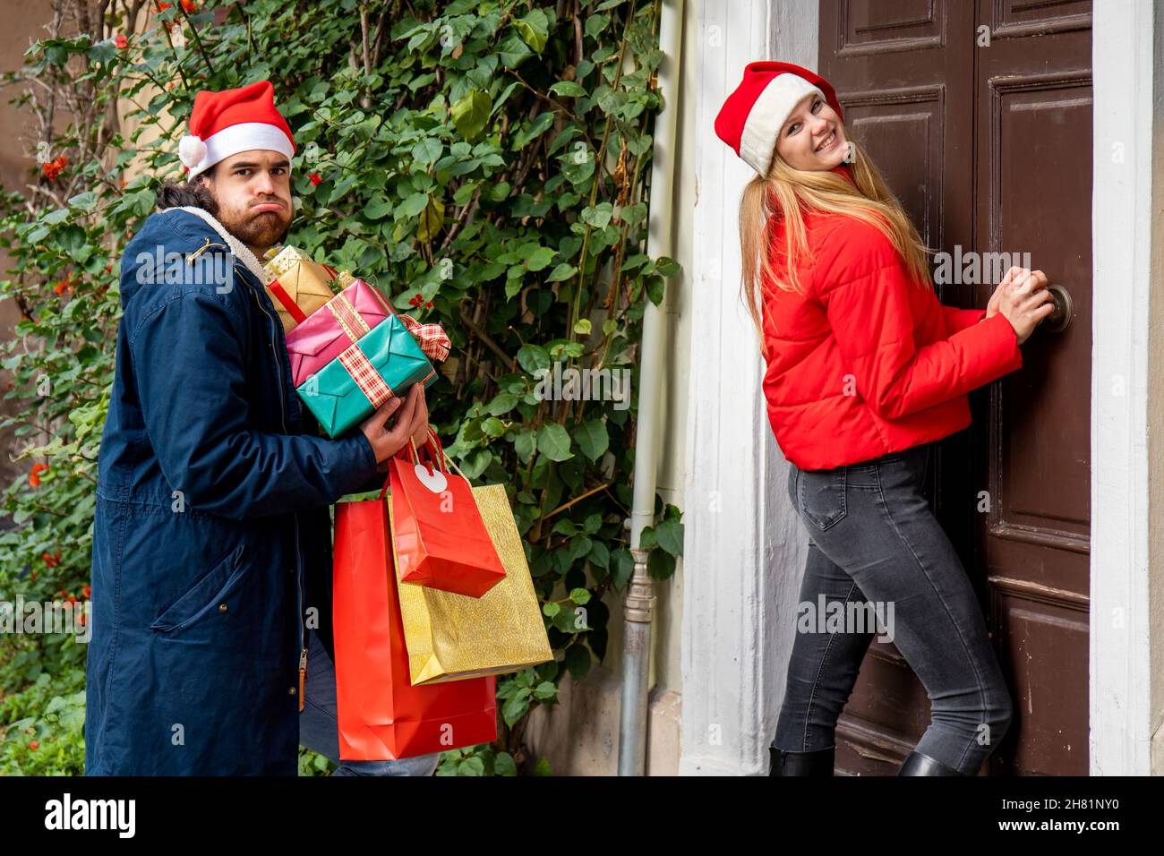 Christmas shopping time. Young couple busy with Christmas gifts outside ...