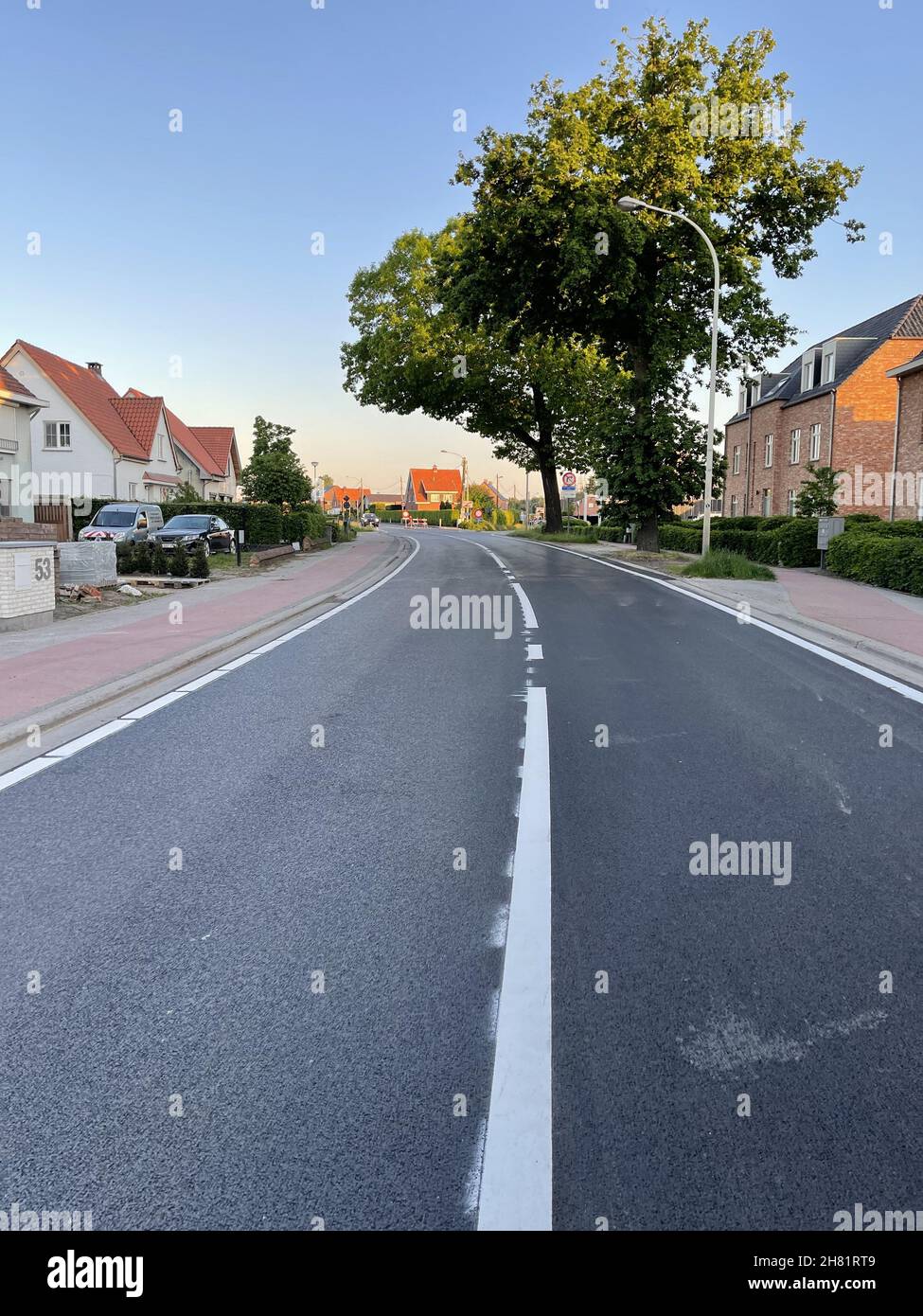 Vertical shot of a curving road along the rows of houses against a ...