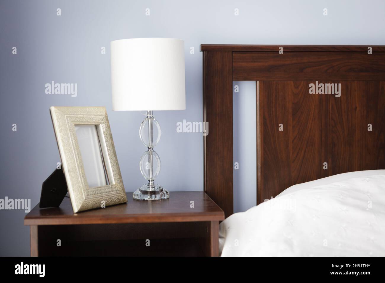 Bedroom, bedside table with lamp and picture frame Stock Photo - Alamy
