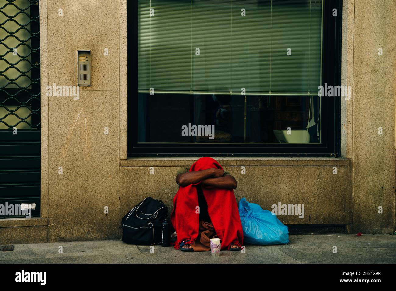 homeless man sitting on the street in milan, italy. High quality photo ...