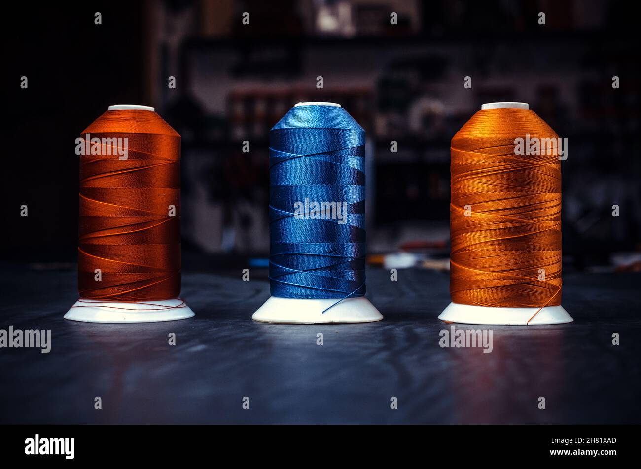 Three bright reel of silk thread on a black background in line Stock ...