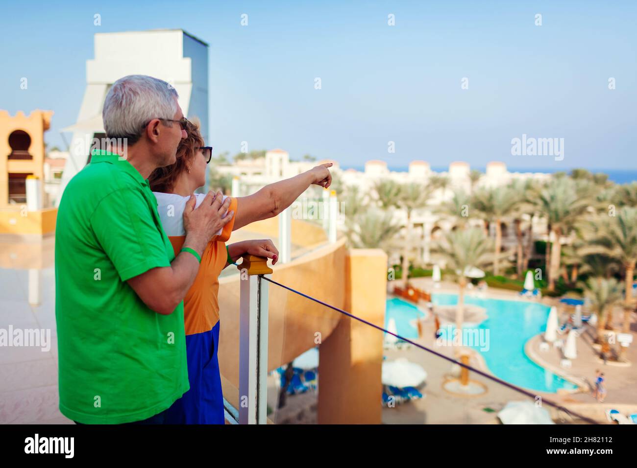 Senior family couple relaxing on tropical hotel territory looking at ...