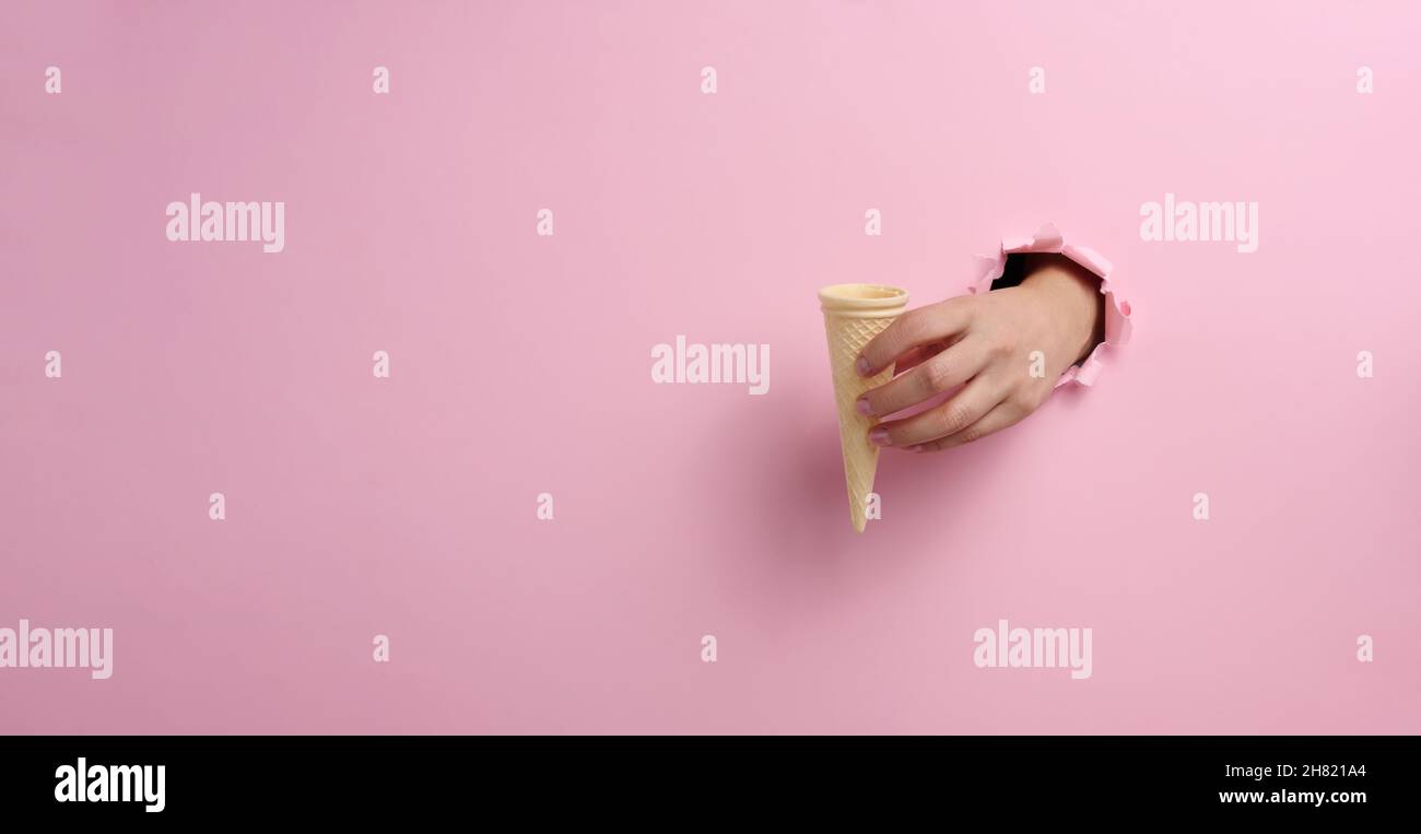 empty waffle cone ice cream cup in a woman's hand sticking out of a ...