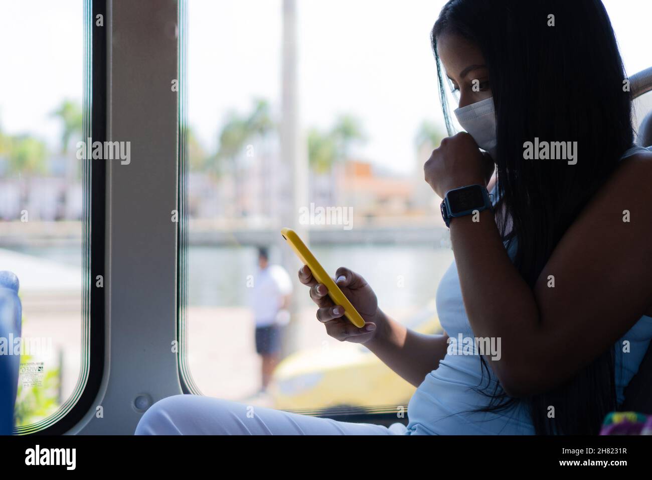 Sick woman in protective mask sitting near the window on a bus during ...