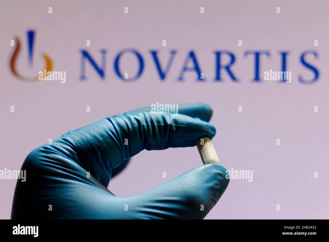 In this photo illustration a Novartis logo is seen on a screen and a ...