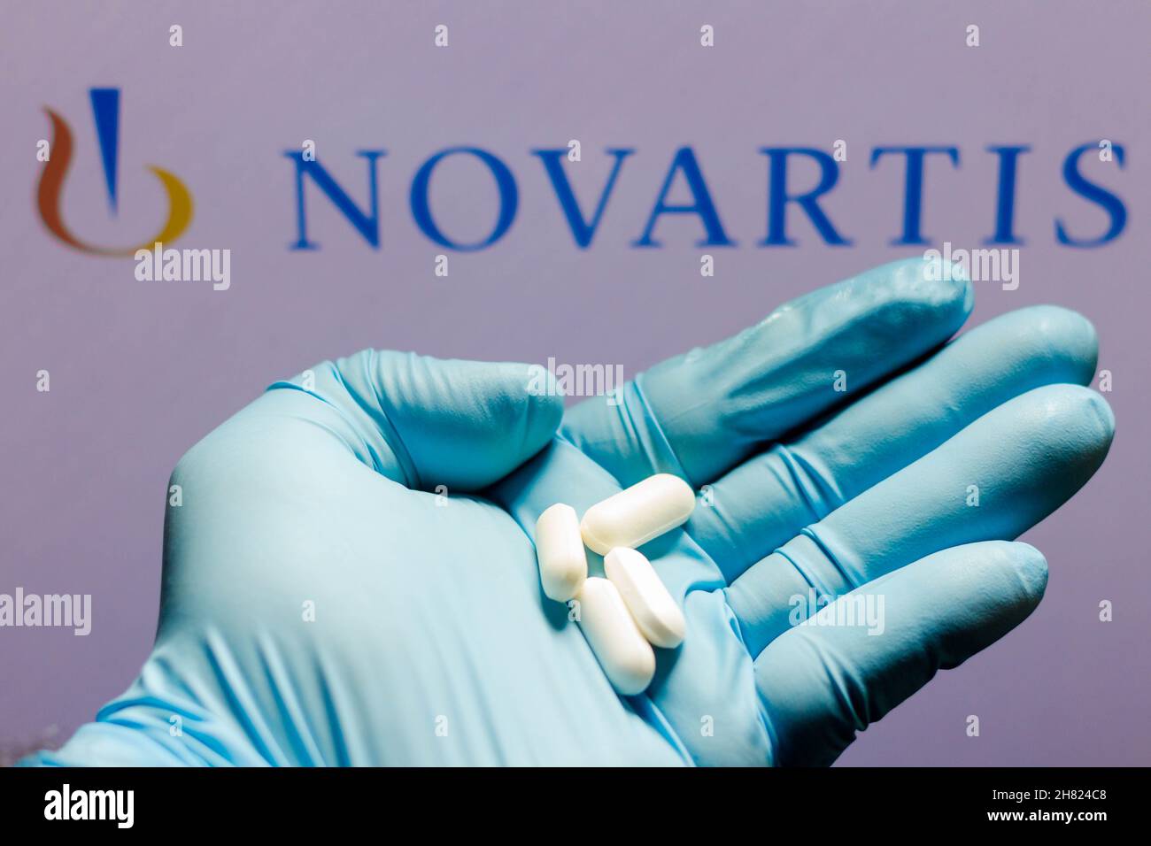 In this photo illustration a Novartis logo is seen on a screen and a ...