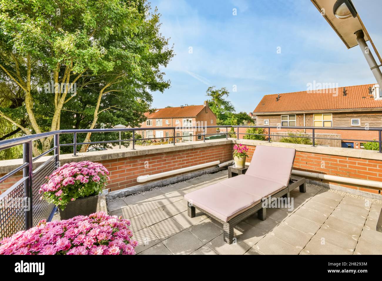 Cozy square balcony with flower pots and a sunbed Stock Photo - Alamy