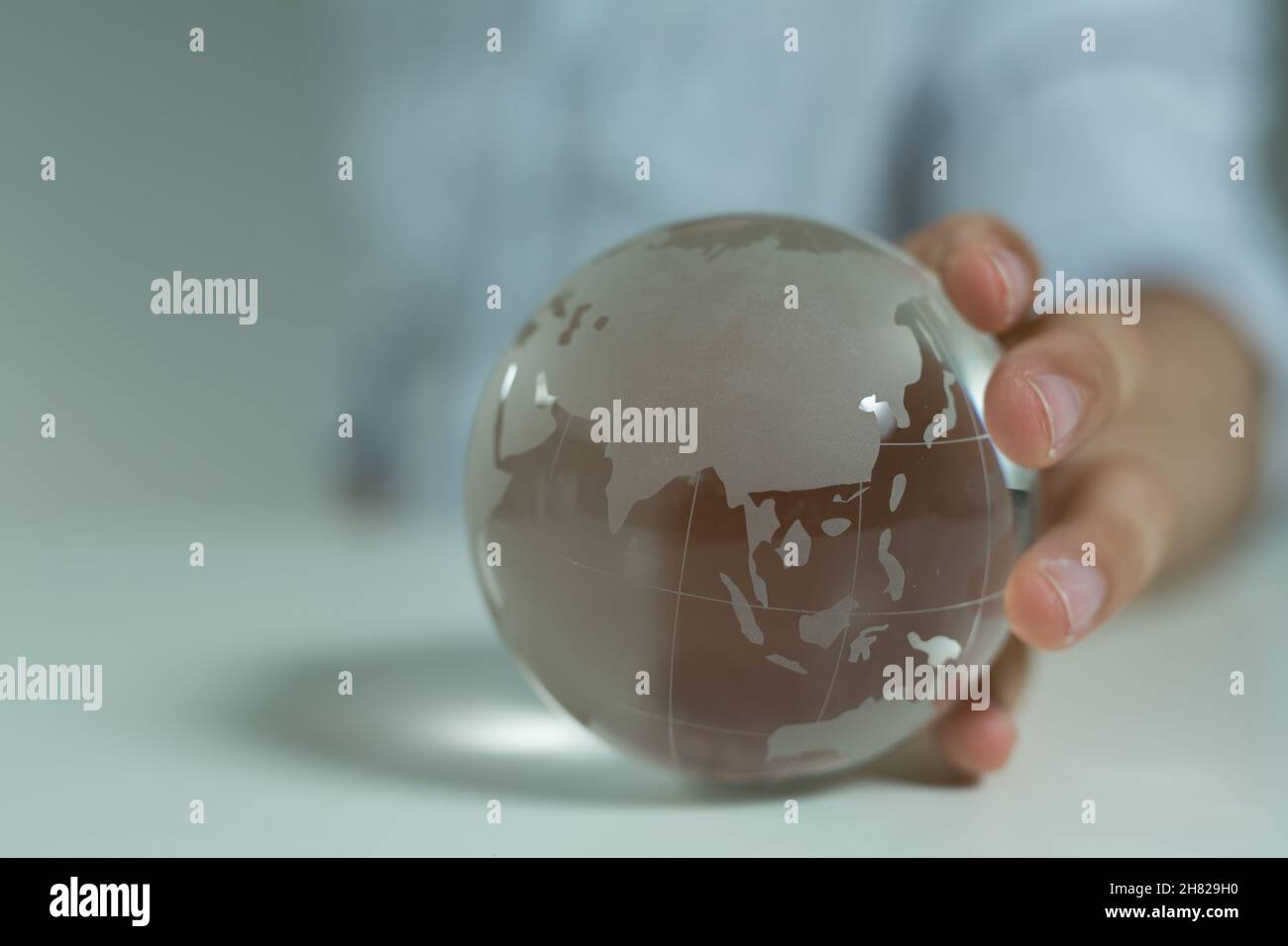 Professional holding a glass globe - global concep Stock Photo - Alamy