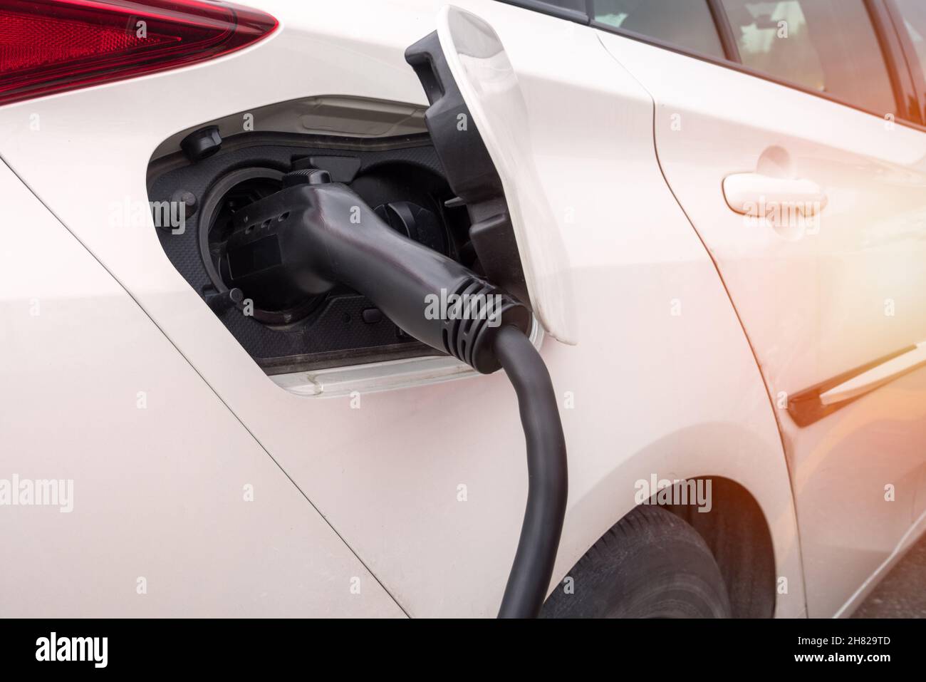 Power supply plugged into an electric vehicle Stock Photo - Alamy