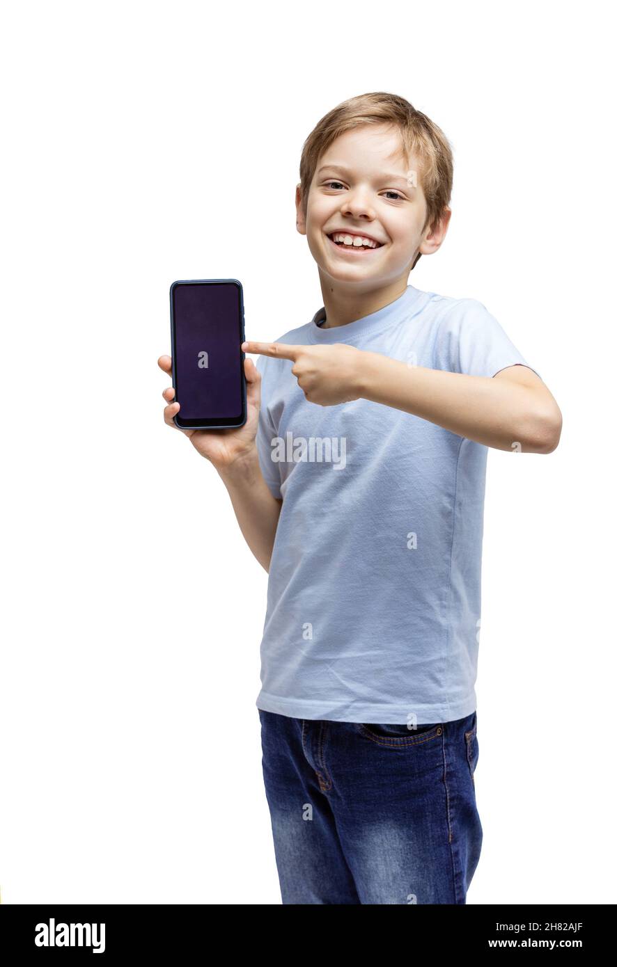 Cute young boy holding and pointing at smart phone, isolated over white ...