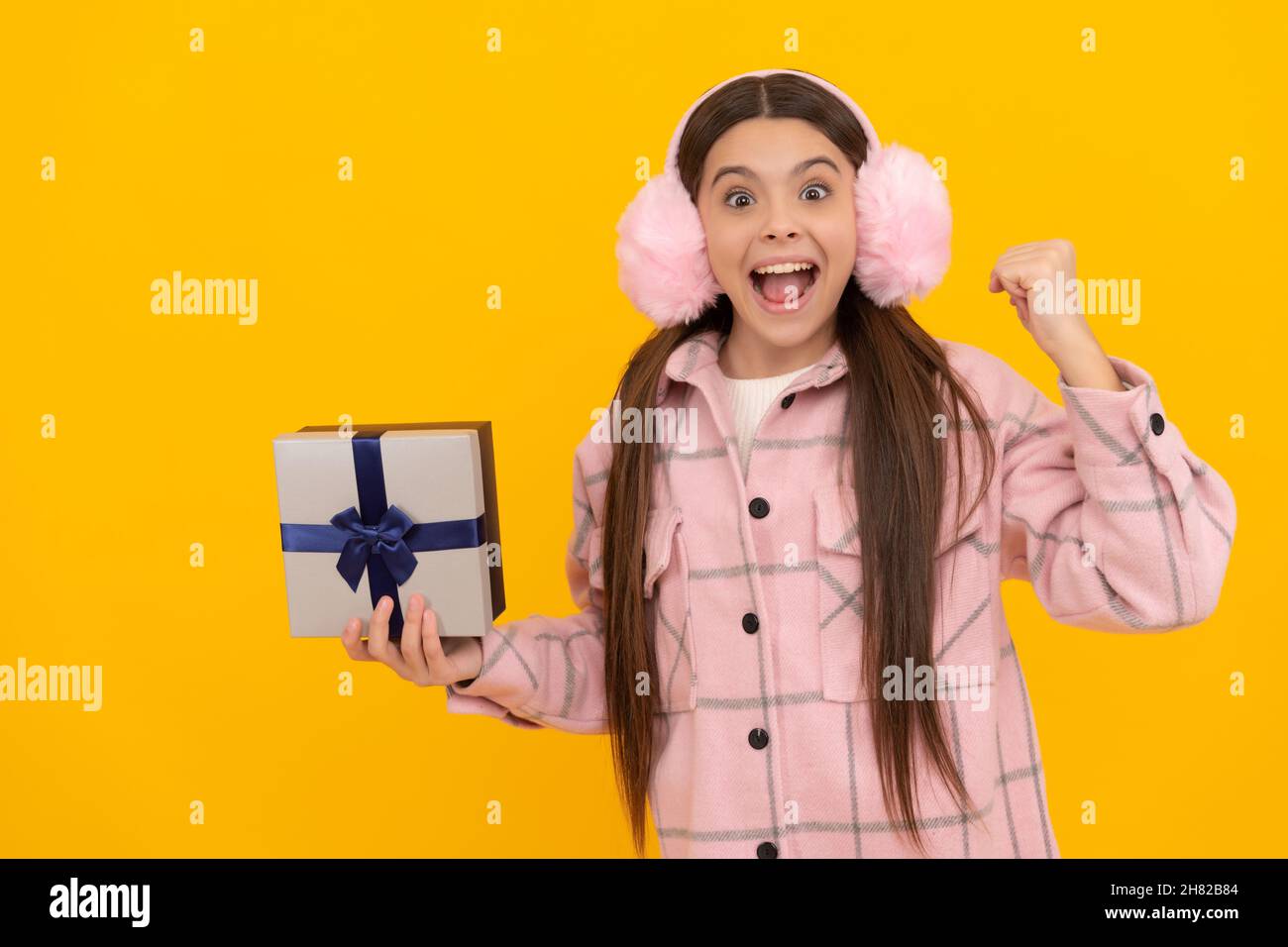 Win a gift. Happy child hold present box making winning gesture. Gift ...