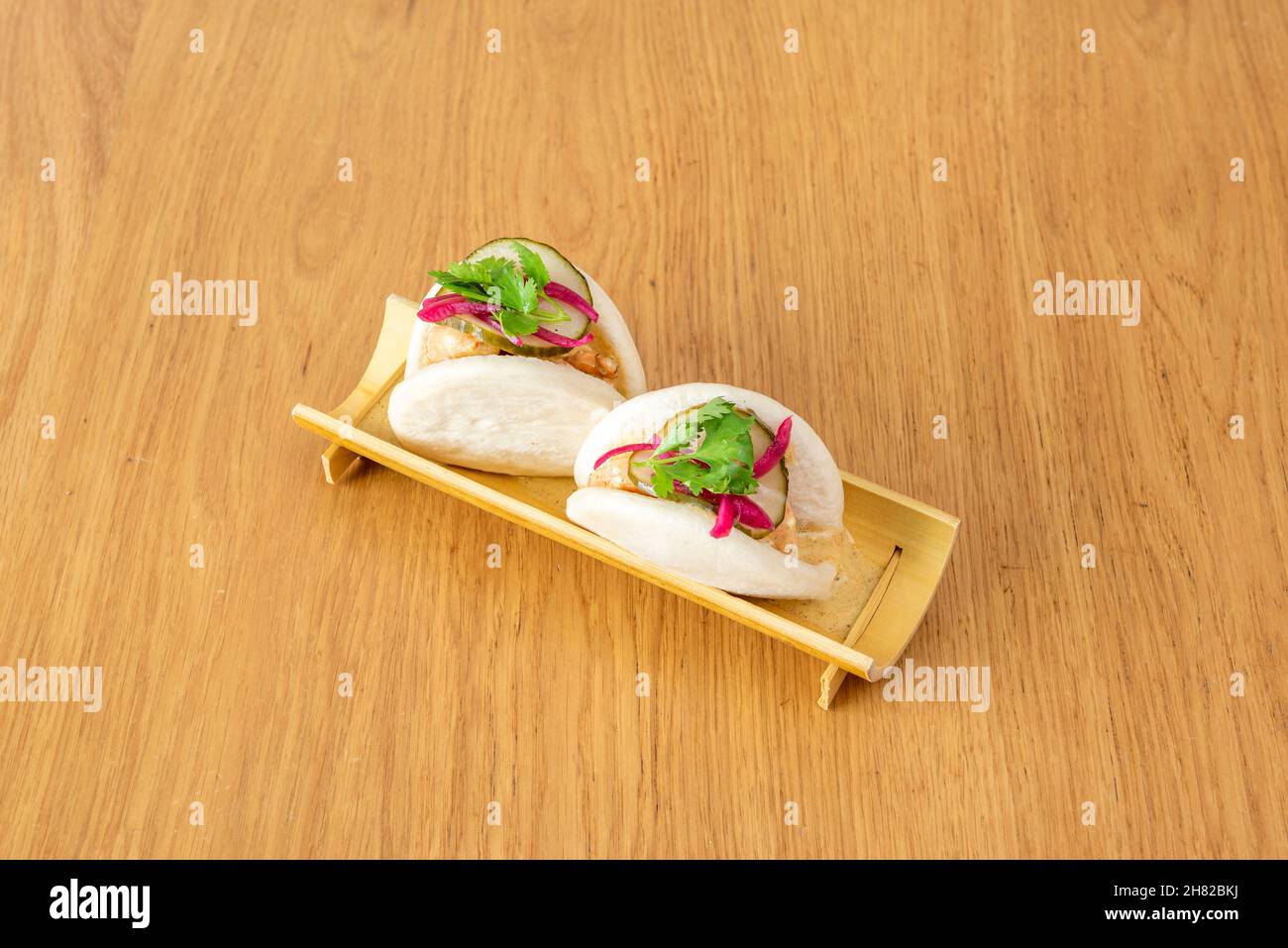 Delicious bao bread with prawns and vegetables with coriander on half a ...