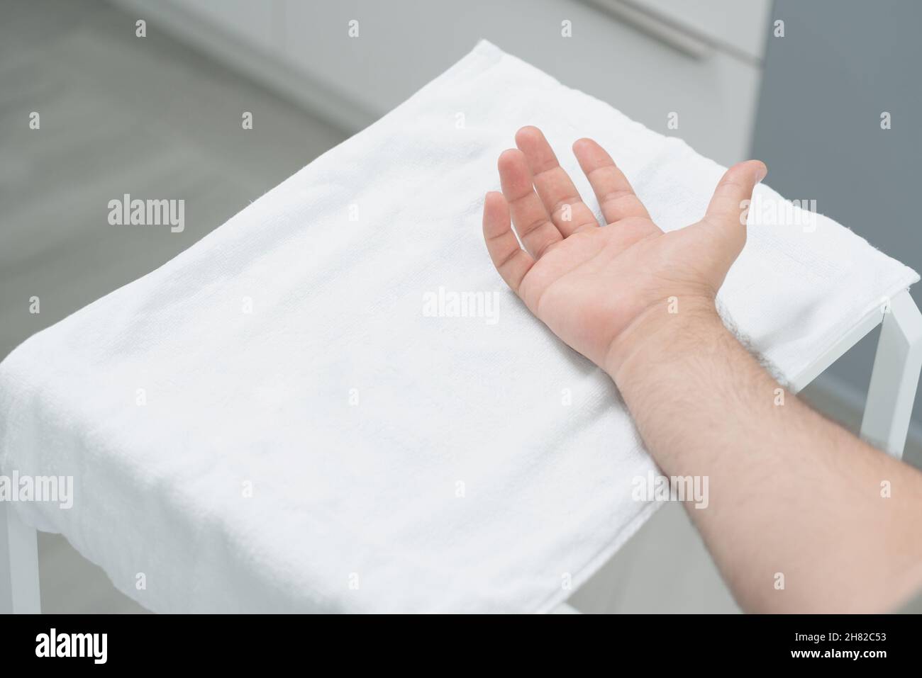 doctor makes a shot of botulinum toxin in the hand of a male palm ...