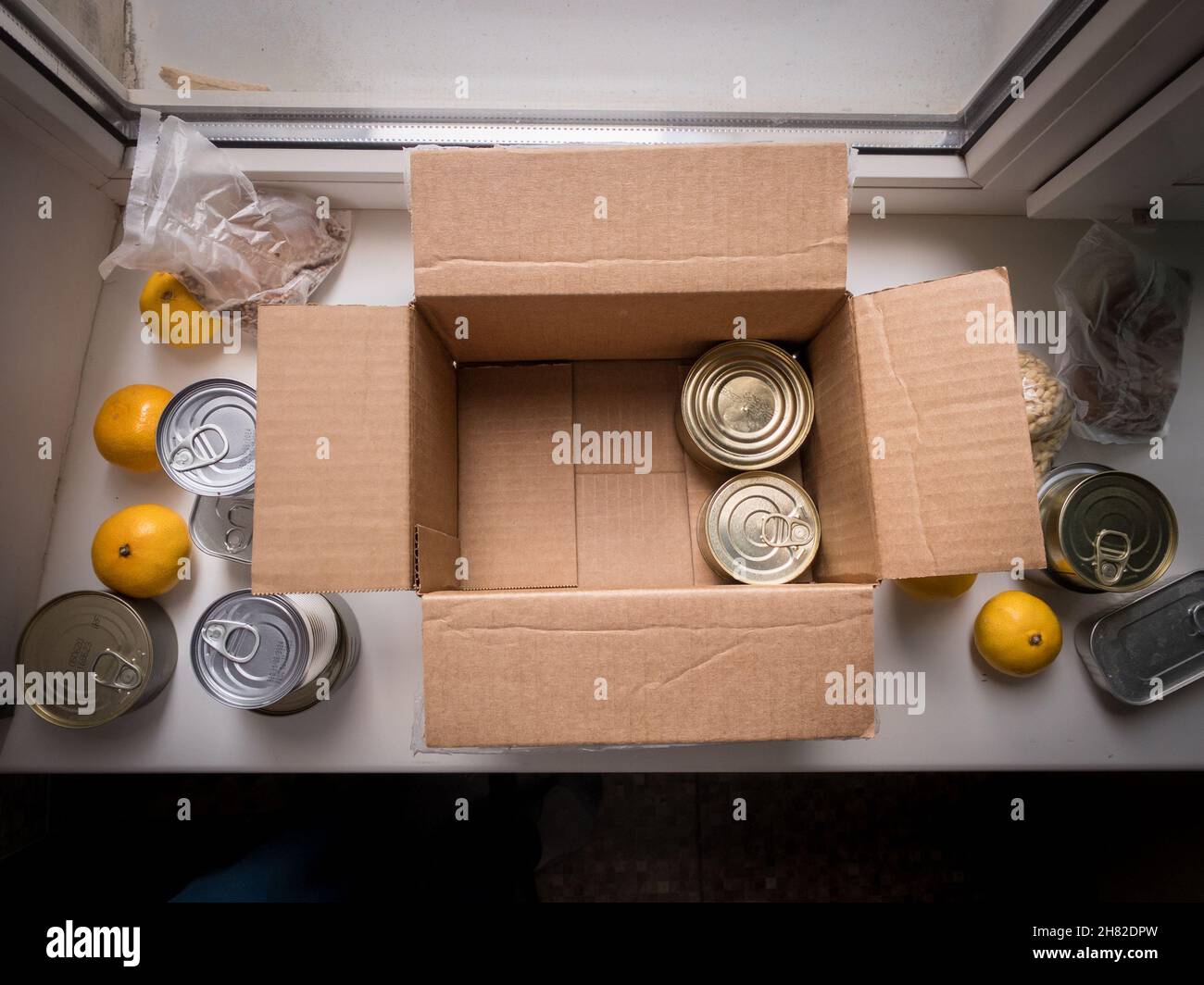 Unpacking Cardboard Box of donations with products: canned food ...