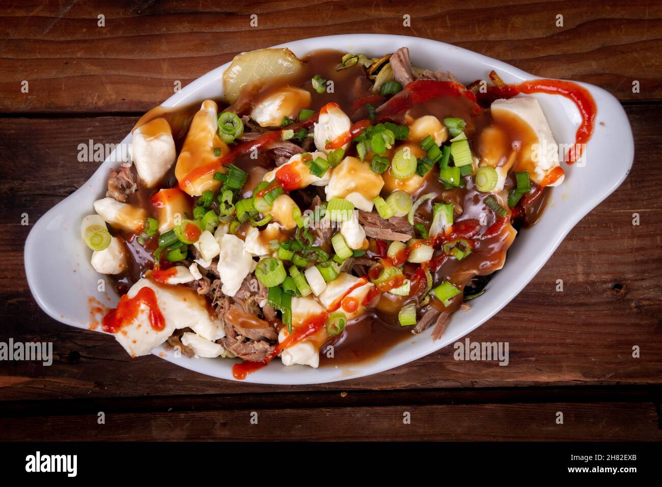 duck confit poutine dish on wood table poutine is a canadian meal made ...