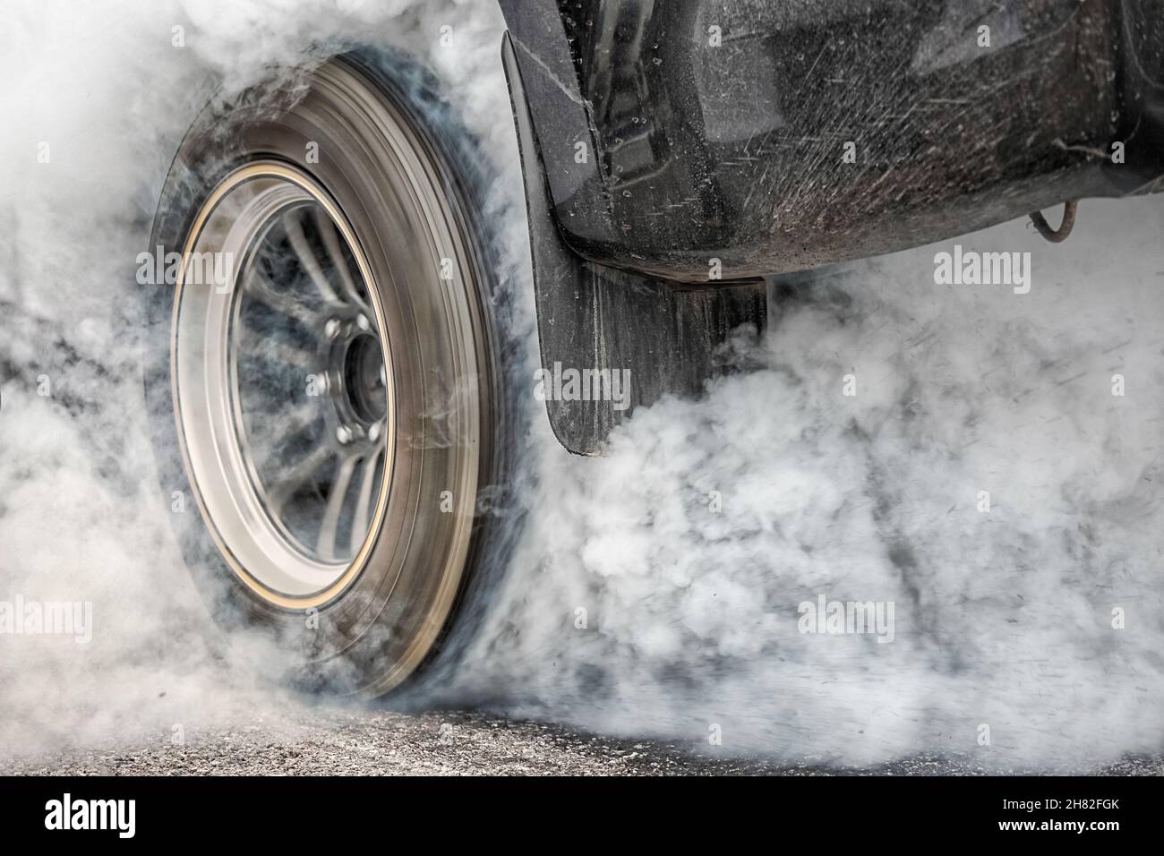 Drag racing car burns rubber off its tires in preparation for the race ...