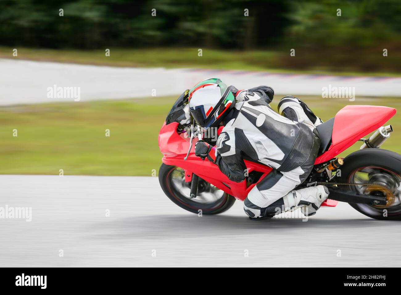 Motorcycle practice leaning into a fast corner on track Stock Photo - Alamy