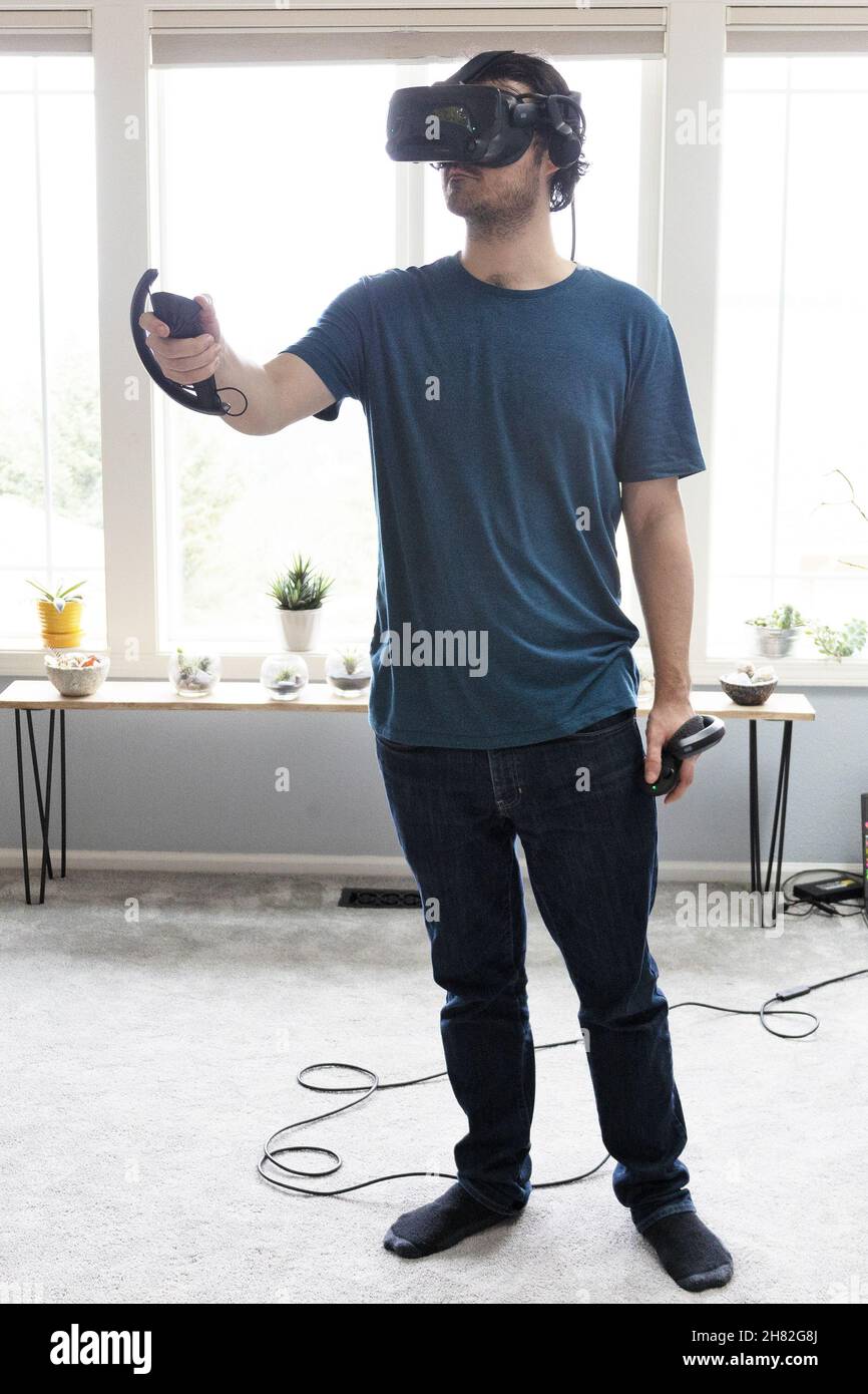 Young man holding virtual reality hi-res stock photography and images ...
