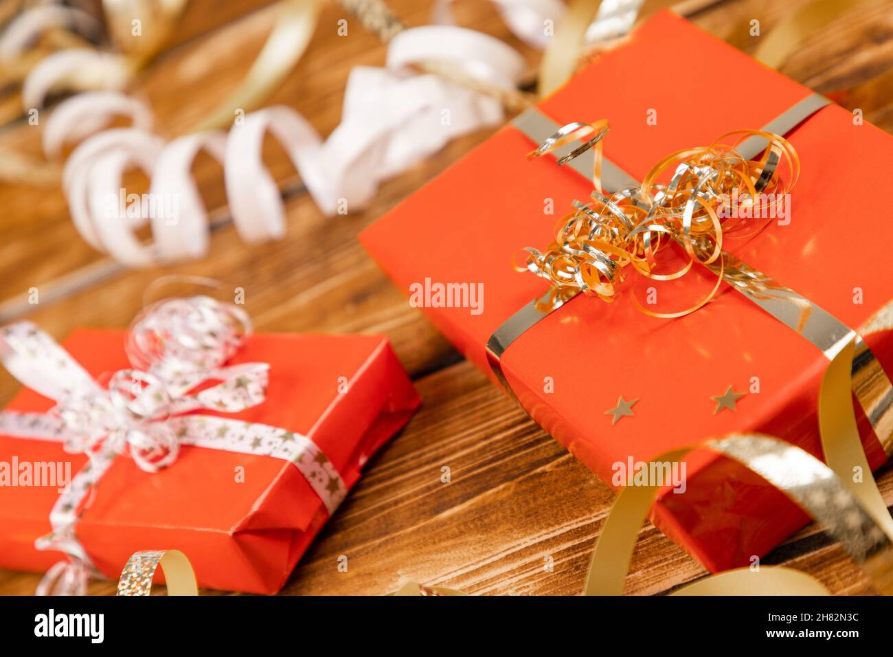 Closeup shot of wrapped red Christmas presents on a wooden table Stock ...