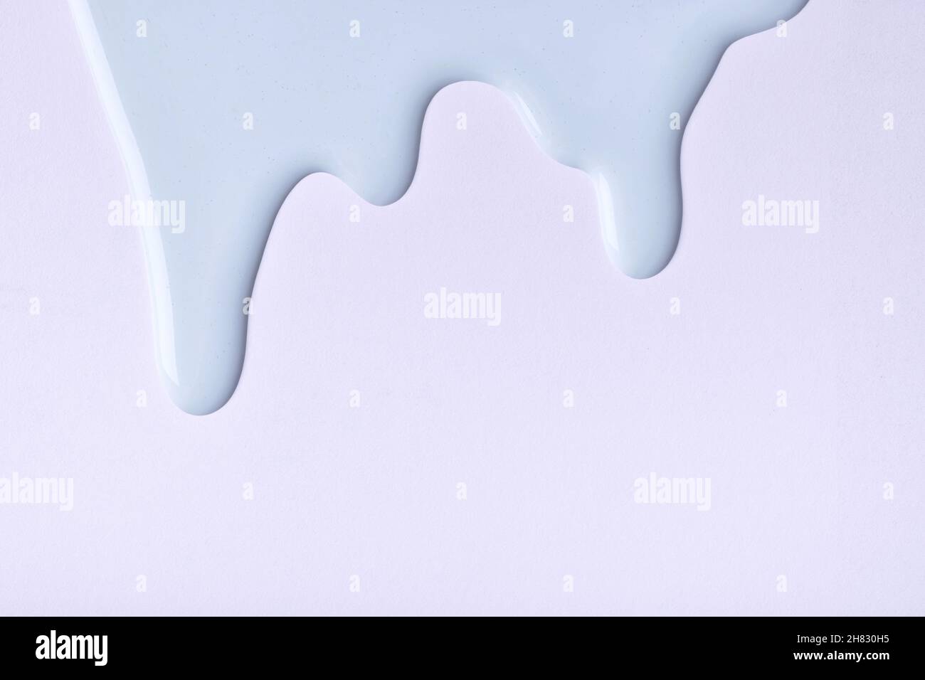 Light blue liquid drops of paint color flow down on gray background ...