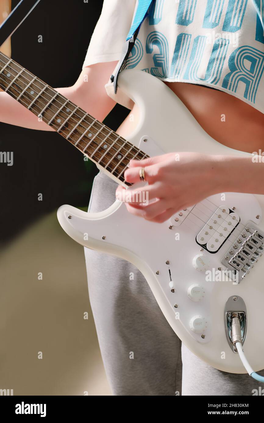female artist playing electric guitar performing a song. crop view ...
