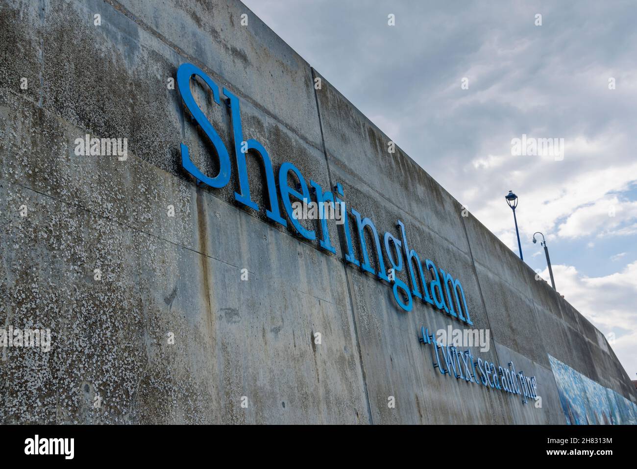 Place name sign on the sea wall at Sheringham, a seaside town on the ...