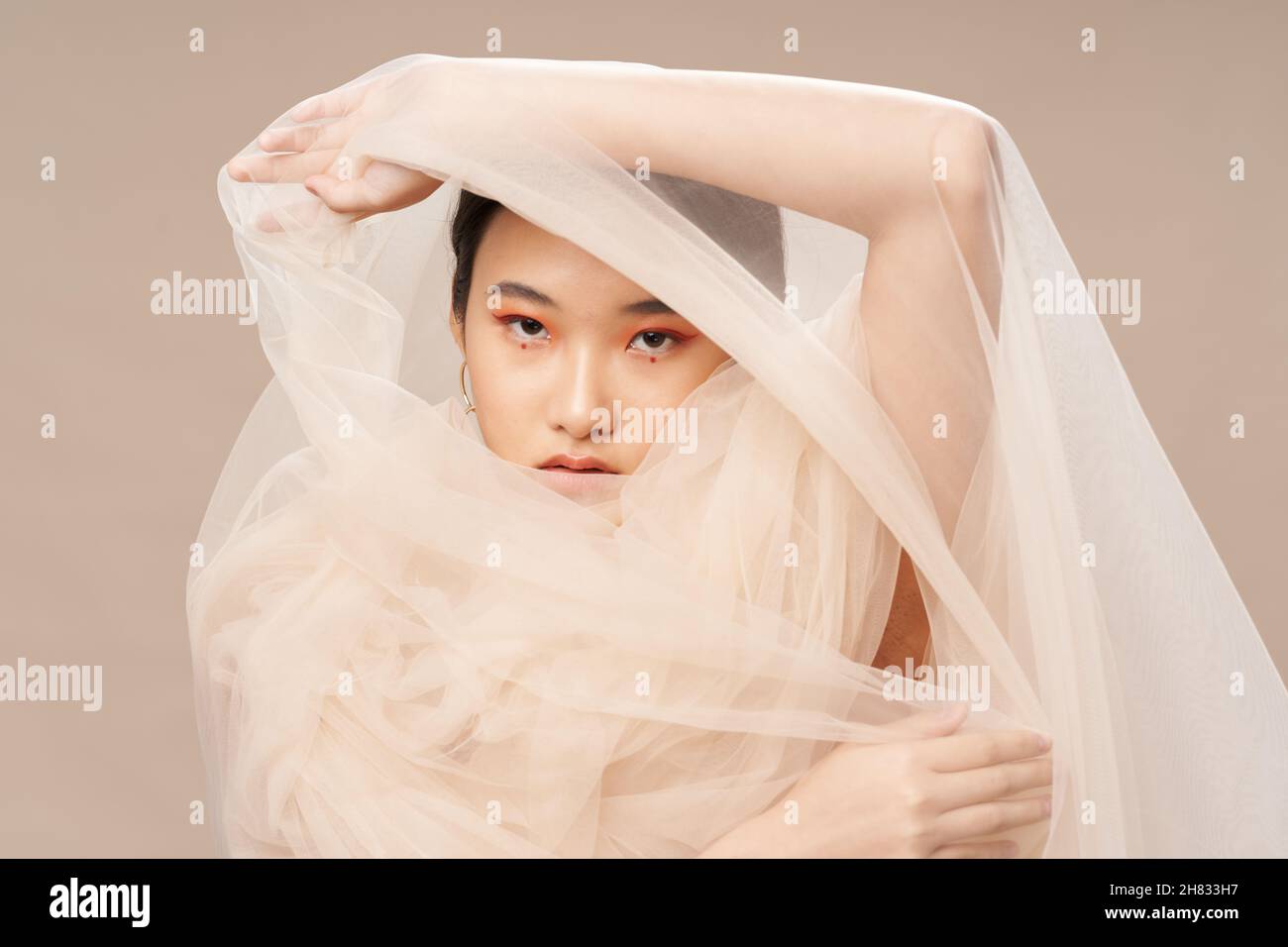 woman wrapped with transparent cloth on gray background cropped view ...