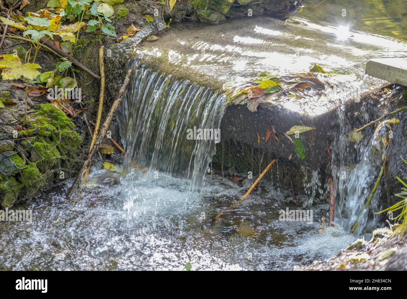 Closeup of mini waterfalls with sun reflection on water Stock Photo - Alamy