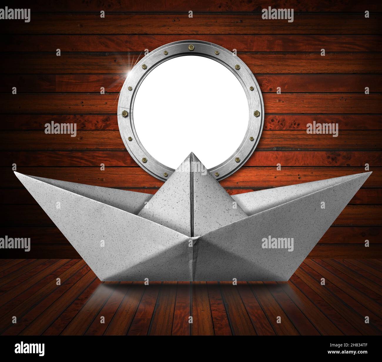White paper boat inside a wooden ship with empty metal porthole with ...