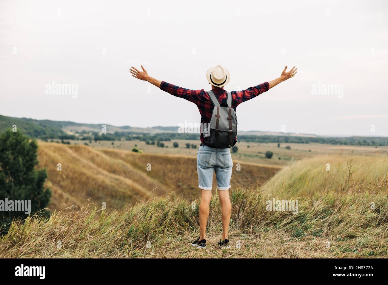 Happy free man standing alone with raised arms during a beautiful ...