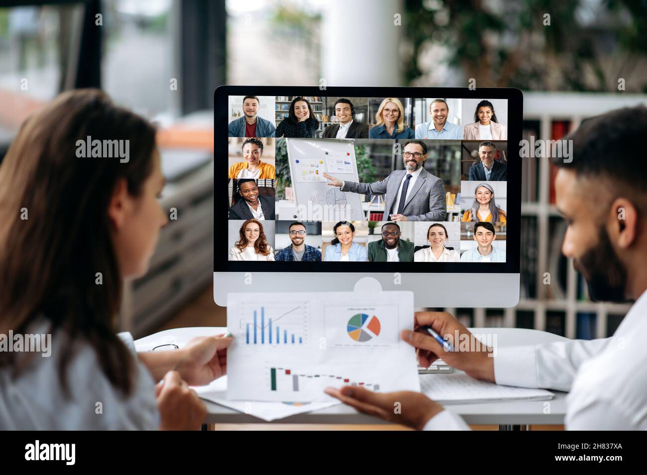 Virtual meeting online, video call. View over shoulders of two ...