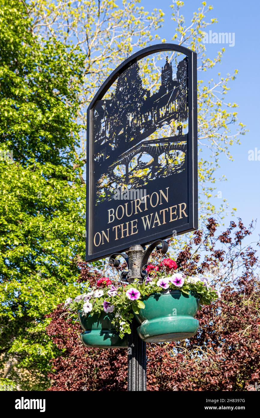 The village sign beside the River Windrush in the Cotswold village of ...