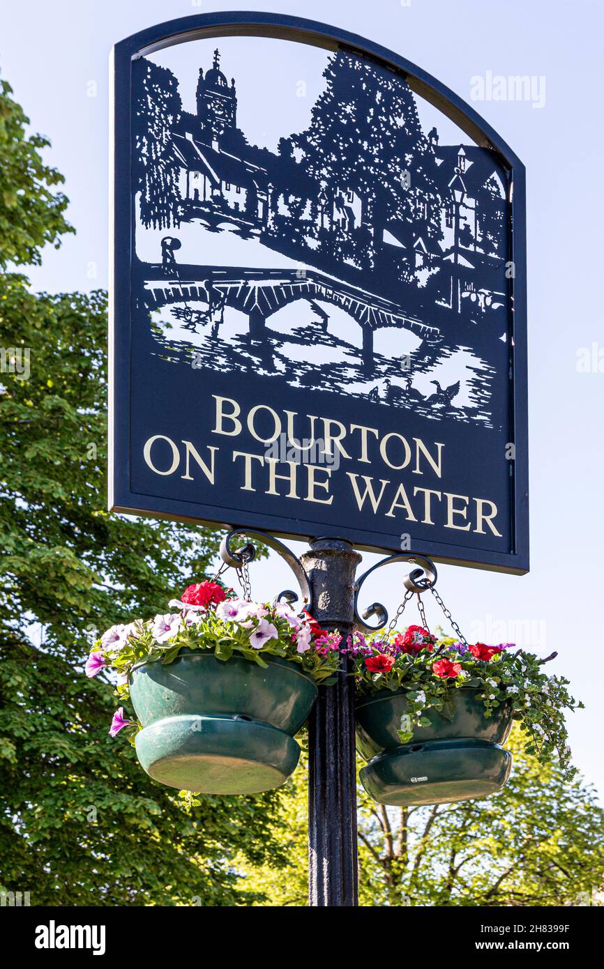 The village sign beside the River Windrush in the Cotswold village of ...