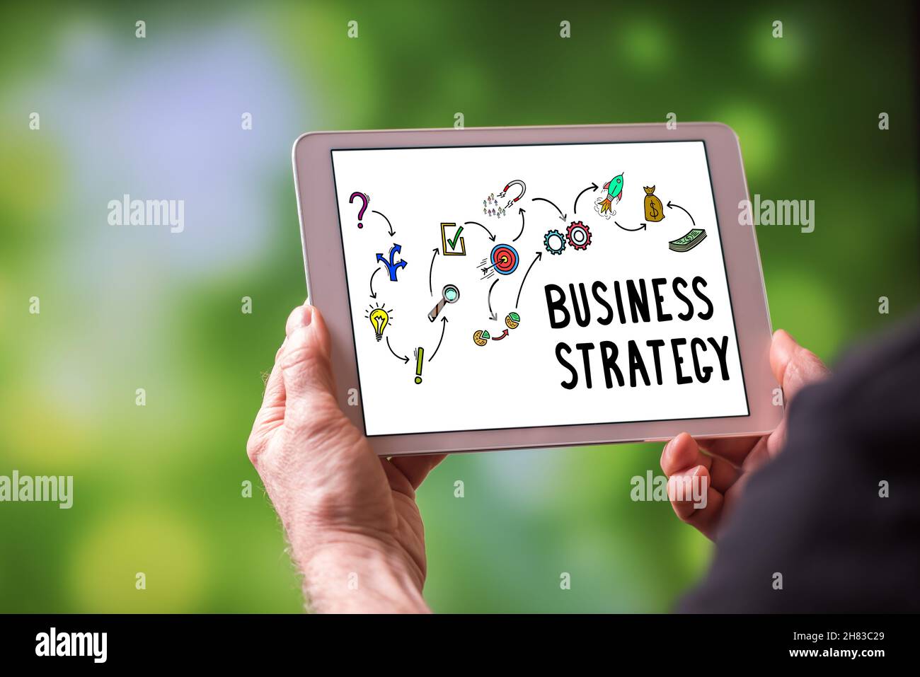 Man holding a tablet showing business strategy concept Stock Photo - Alamy