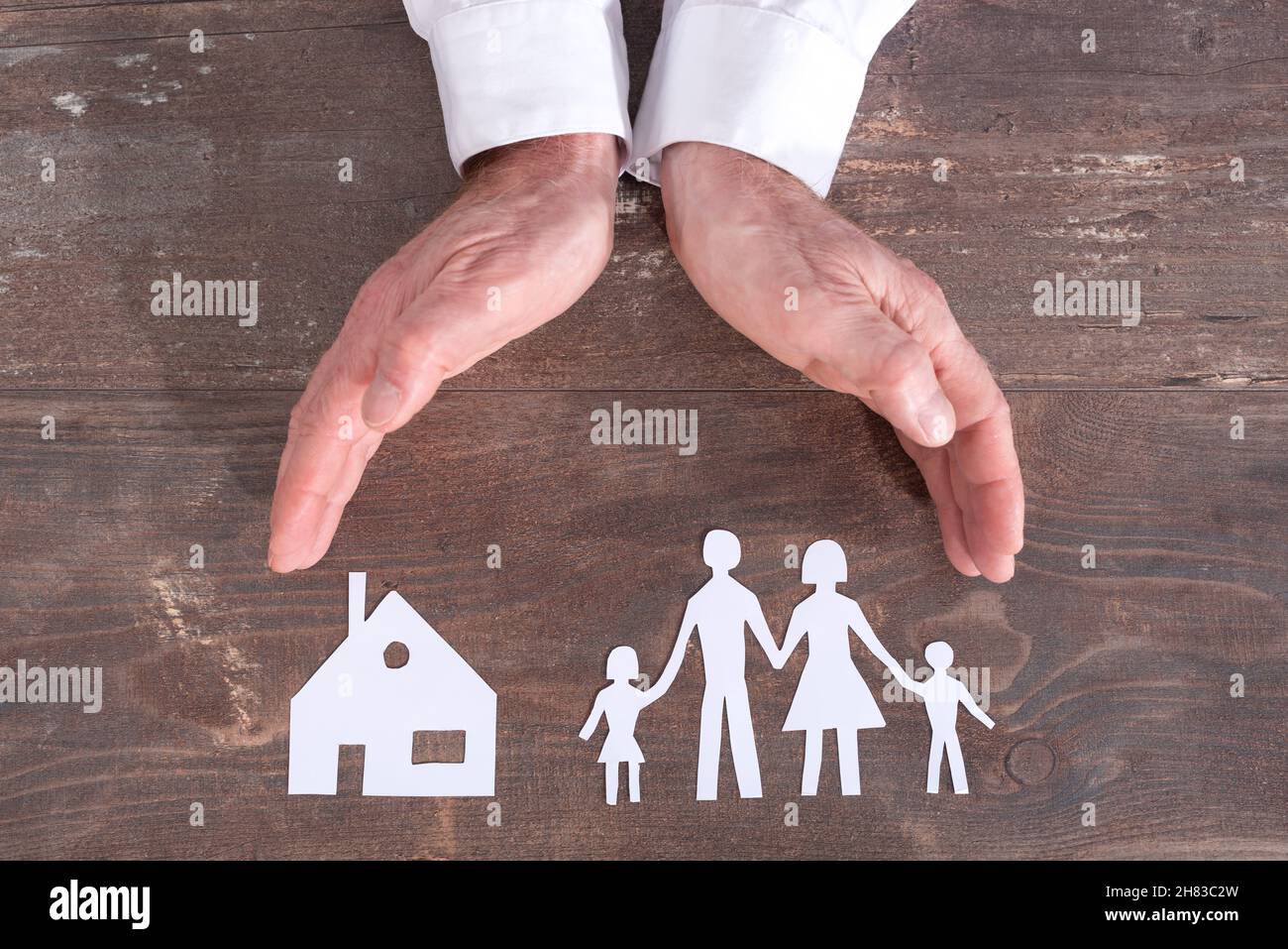 Family and house covered by hands - insurance concept Stock Photo - Alamy