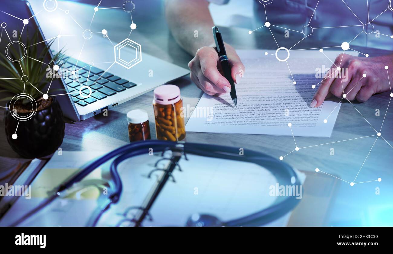 Female doctor reading medical report in medical office; light effect ...