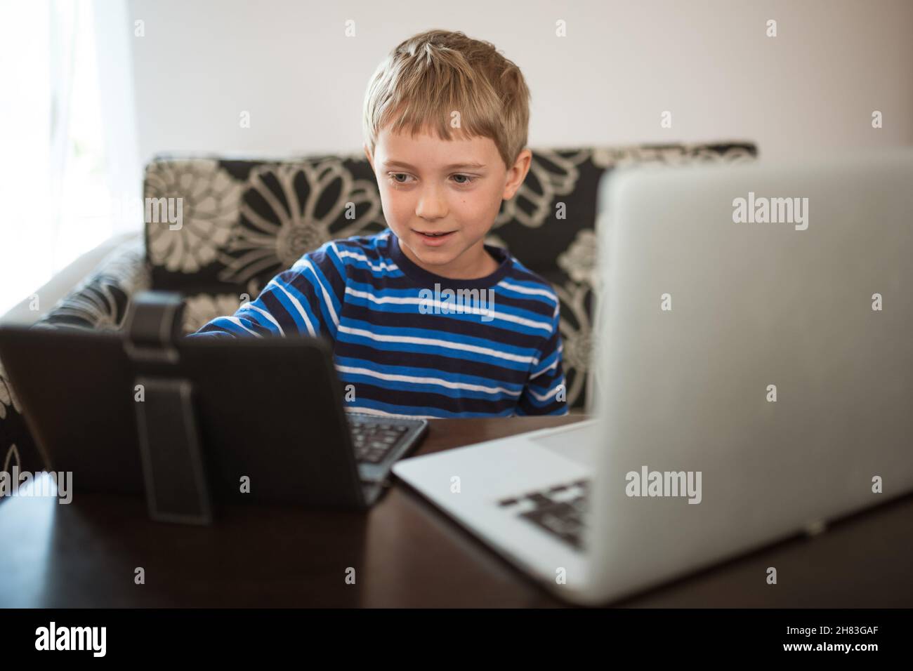 Young boy plays on the tablet and laptop Stock Photo - Alamy