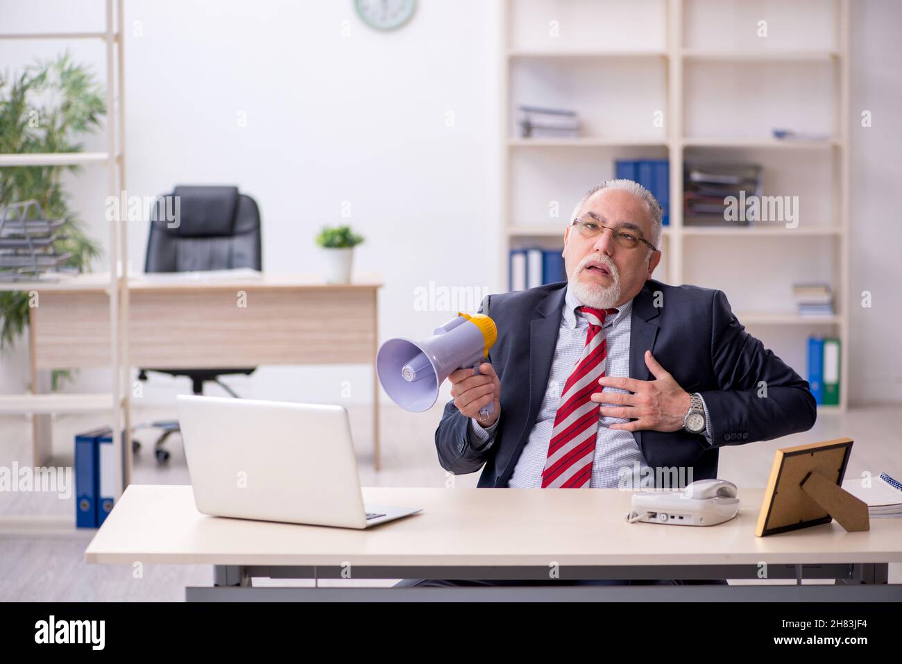 Angry boss holding megaphone in the office Stock Photo - Alamy