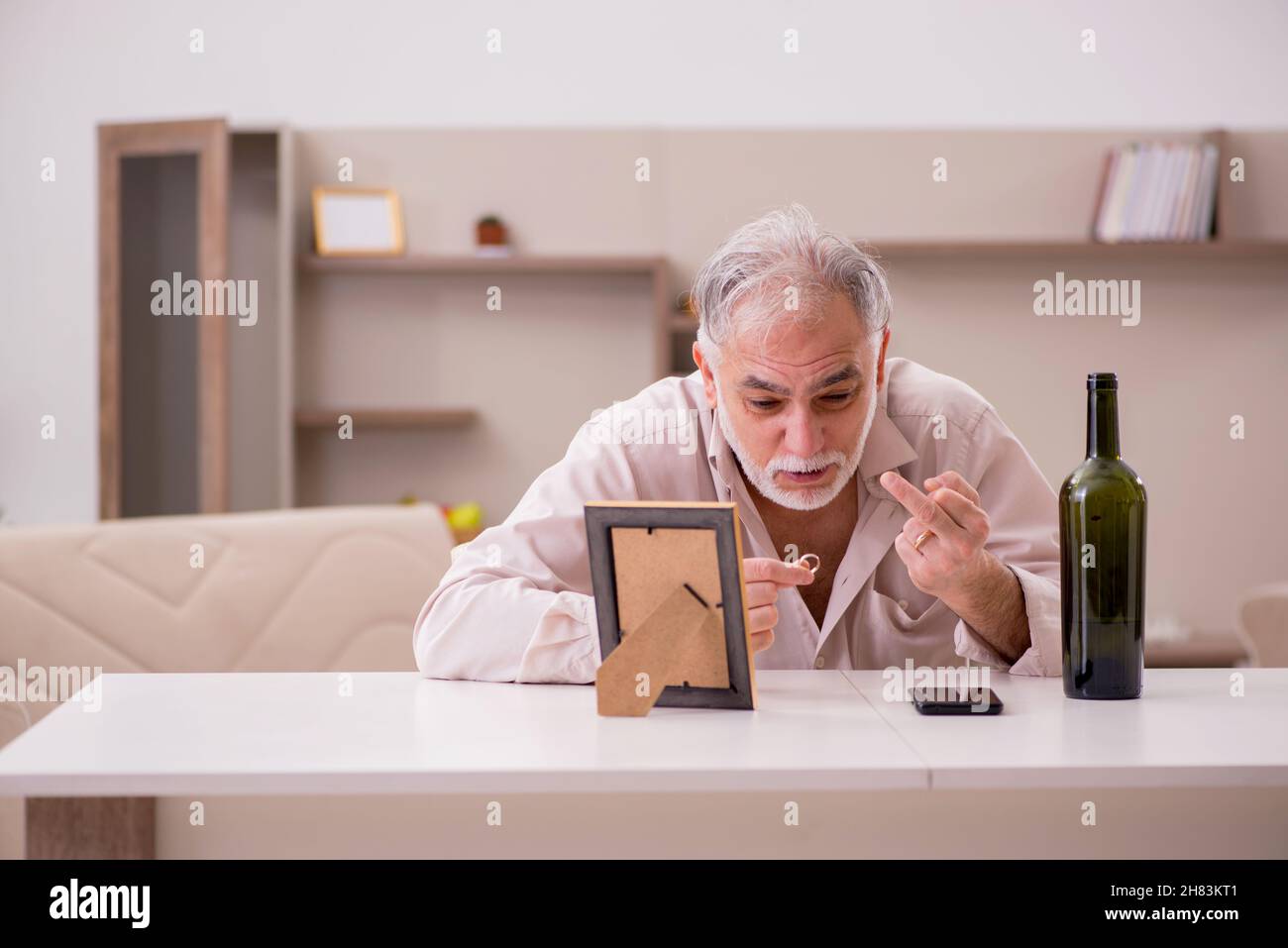 Aged widower drinking alcohol at home Stock Photo - Alamy