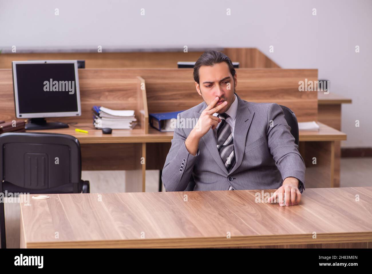 Young male employee working at workplace Stock Photo - Alamy