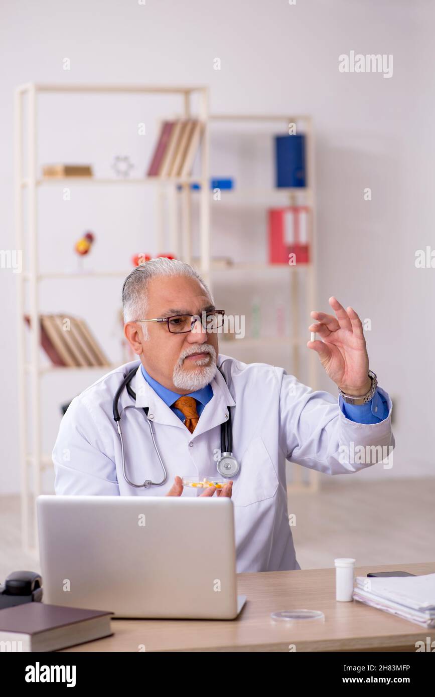 Old doctor working in the clinic Stock Photo - Alamy