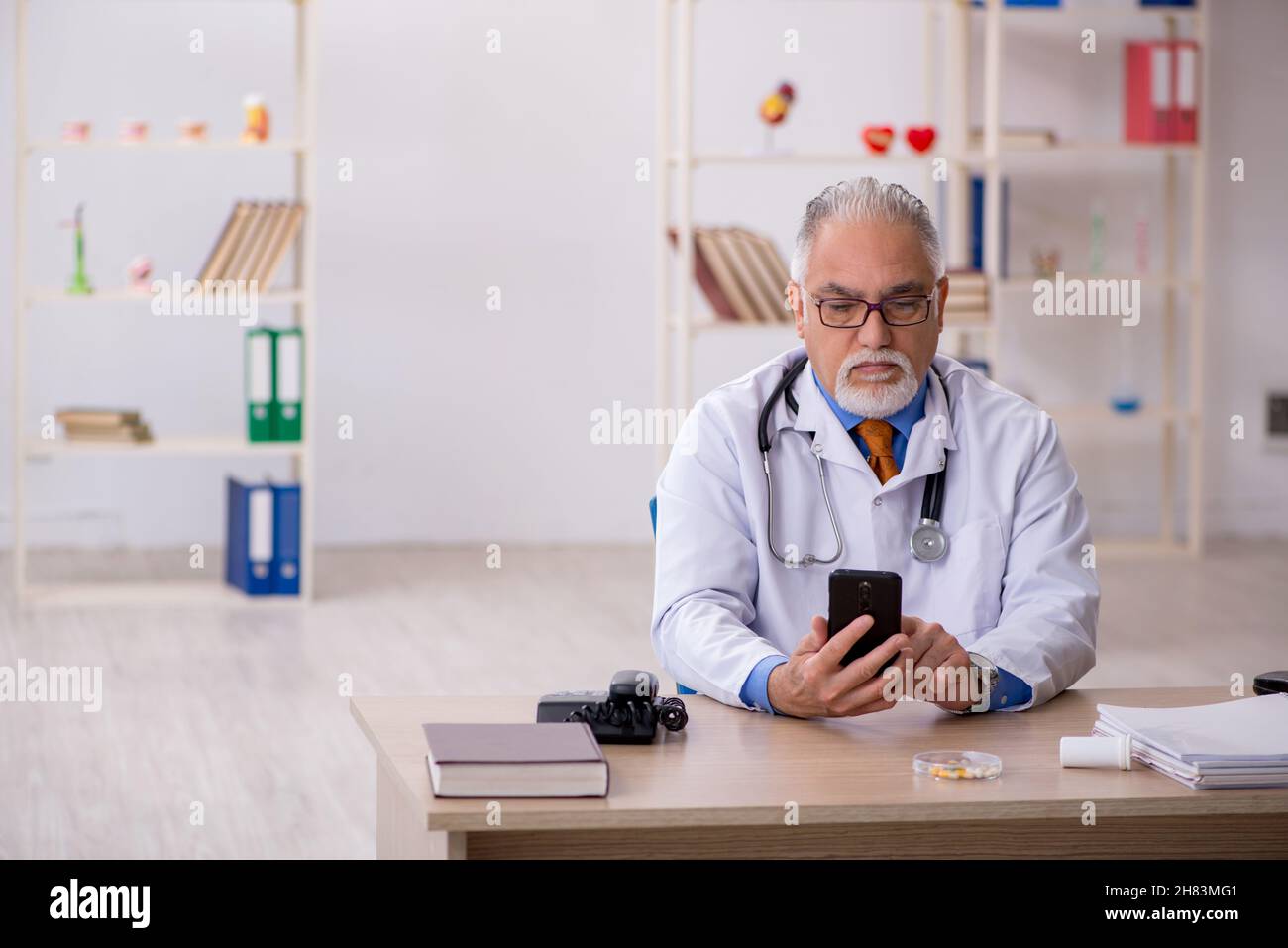 Old doctor working in the clinic Stock Photo - Alamy