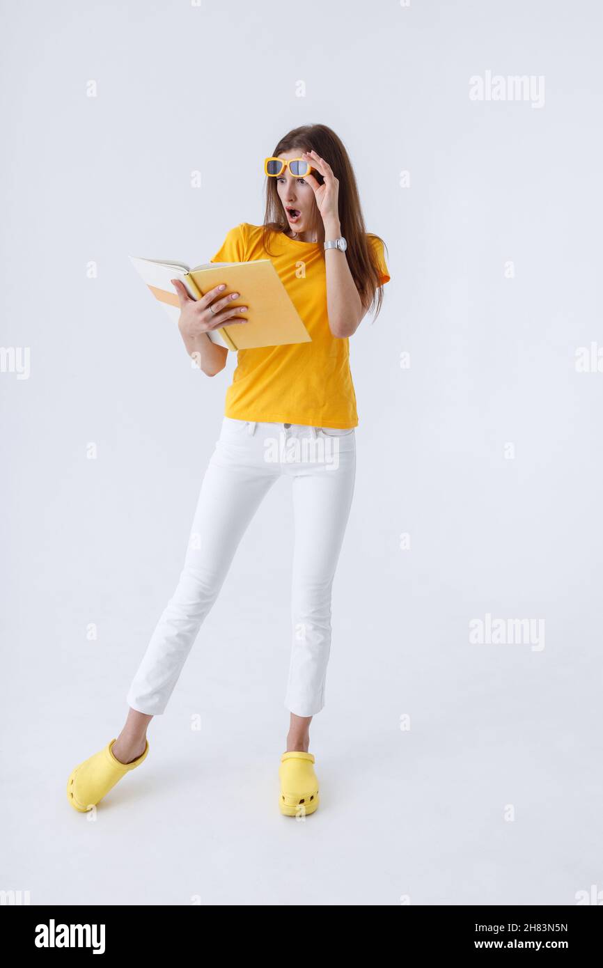 Shocked woman reading exciting book in studio Stock Photo - Alamy