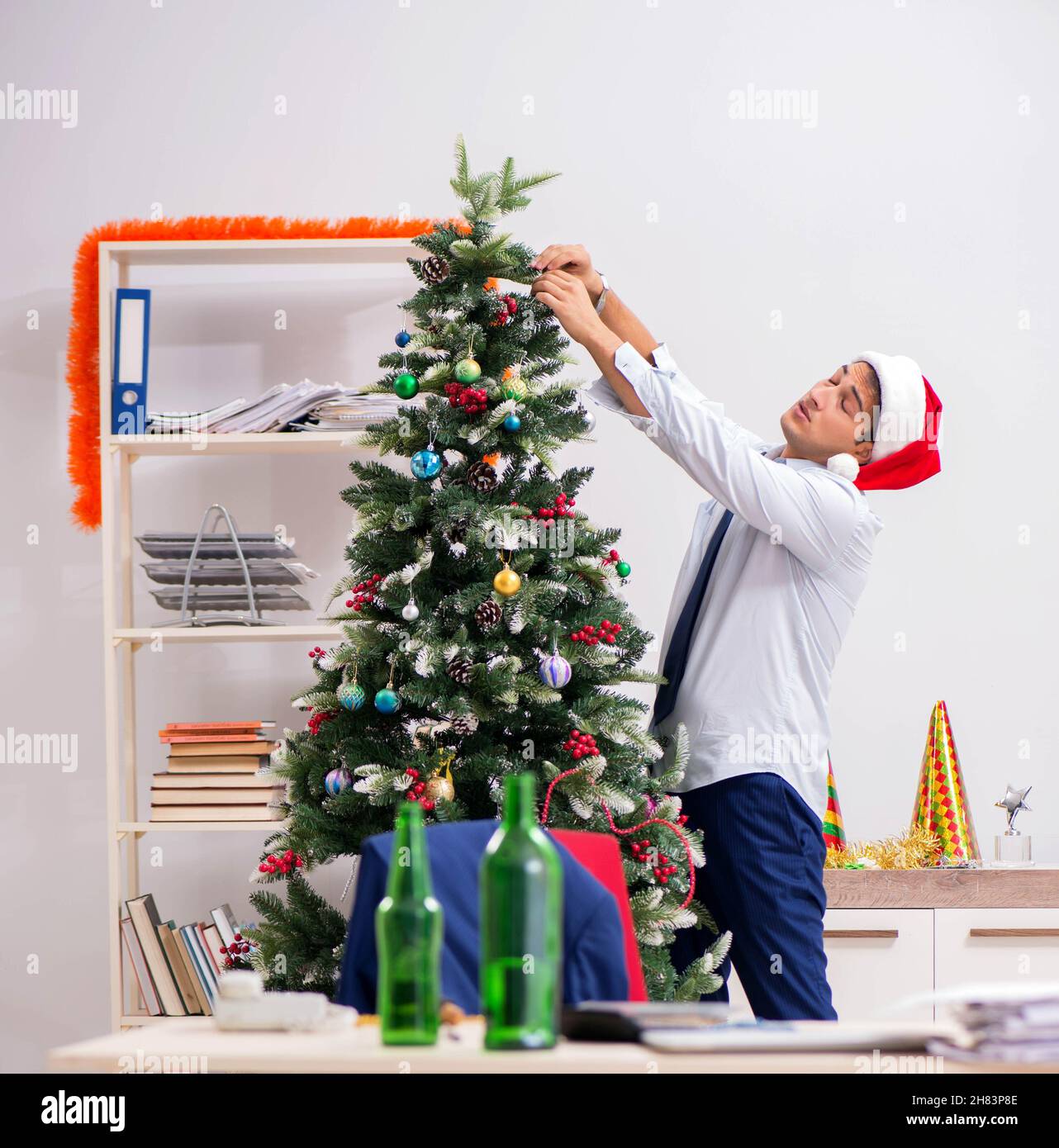 The young handsome employee celebrating christmas at workplace Stock ...