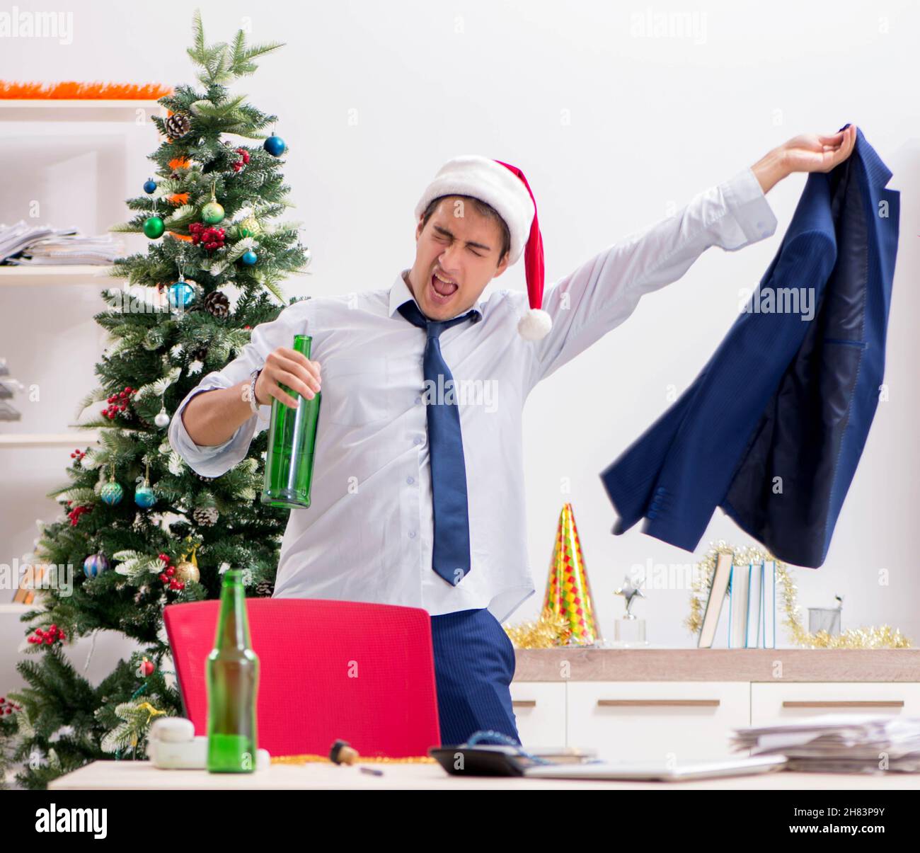 The young handsome employee celebrating christmas at workplace Stock ...